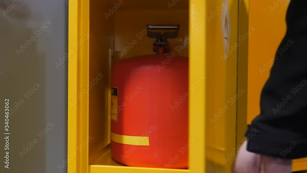 Man's hand opening yellow color metal box container with gas cylinder ...