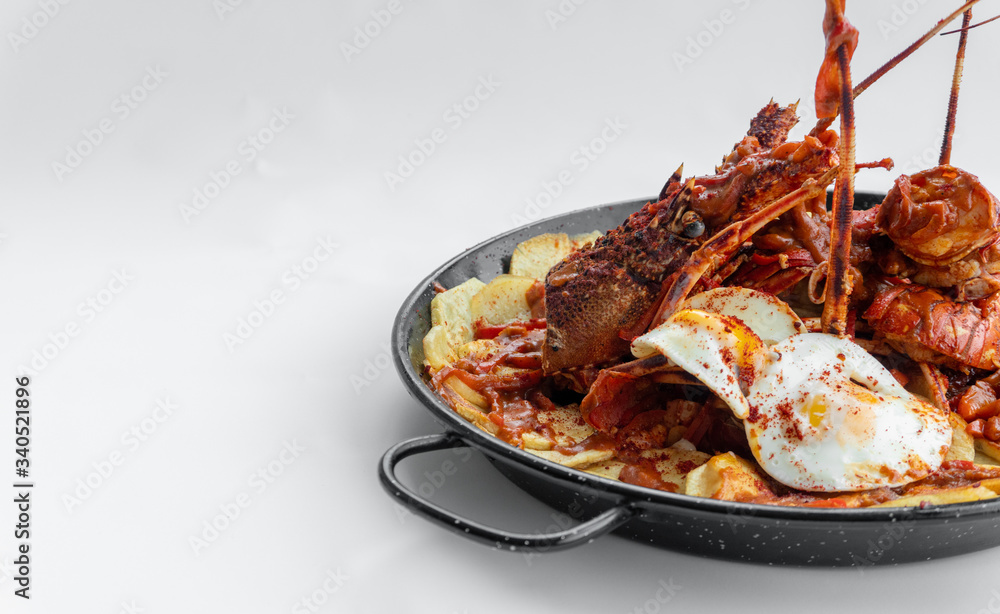 Formentera Lobster with fried potatoes, eggs and parsley in a ...