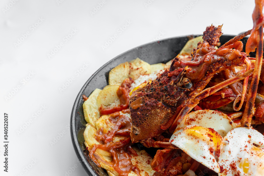 Formentera Lobster with fried potatoes, eggs and parsley in a ...