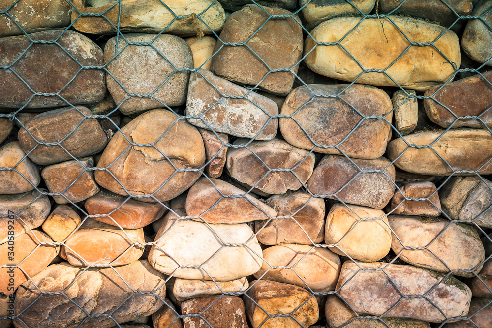wire netting holding stones from a wall. stone background Stock Photo ...