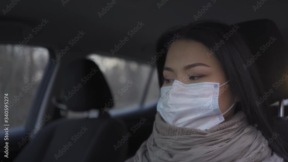Asian female doctor going home sitting in the car fter a long shift ...