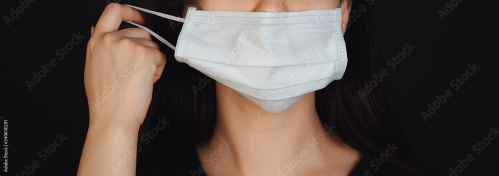 medical mask on a female face is removed with one hand for an elastic ...