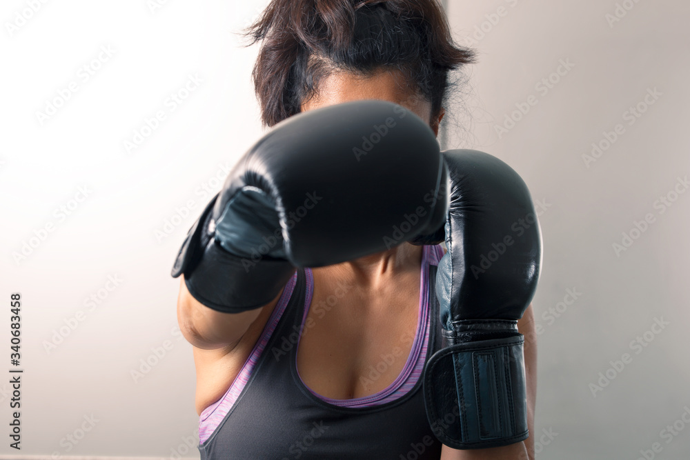 A brunette girl learns fighting techniques of self-defense in boxing ...
