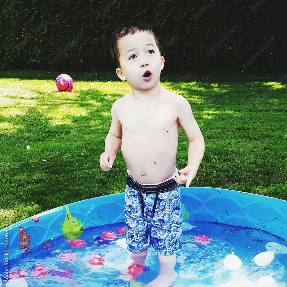 Foto de Shirtless Boy Standing In Wading Pool do Stock | Adobe Stock