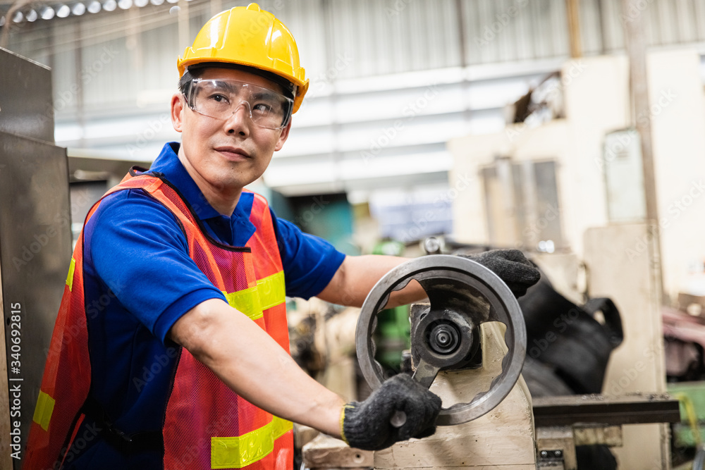 Portrait of smart asian industrial worker wearing uniform and yellow ...