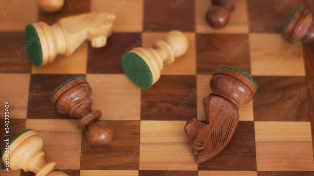 Wooden chess pieces are in a mess on a chessboard. From left to right ...