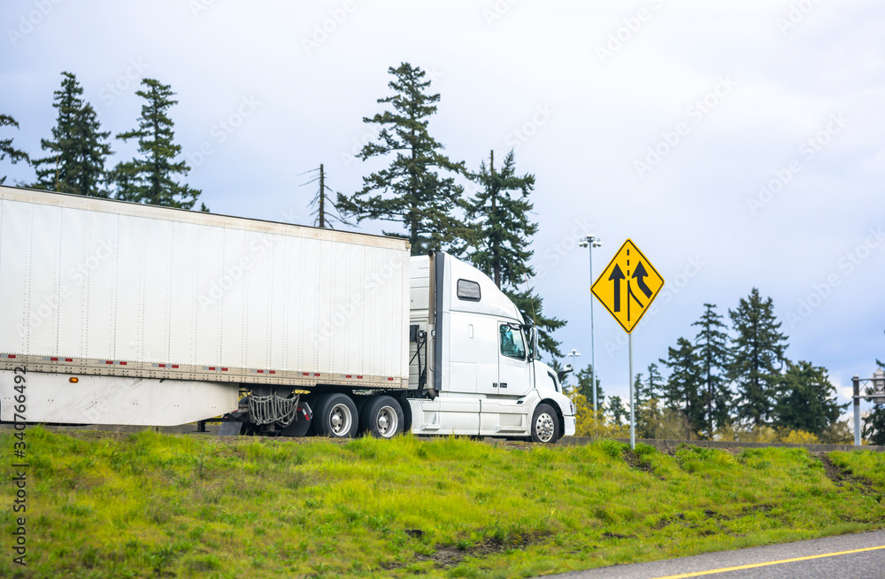 Big rig day cab semi truck with bulk semi trailer turning on the ...