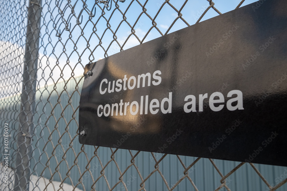 A black and white sign in English and French which says customs ...