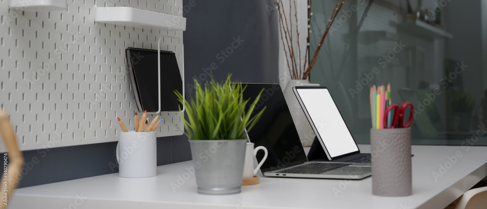Side view of minimal office desk with mock-up digital devices, supplies ...