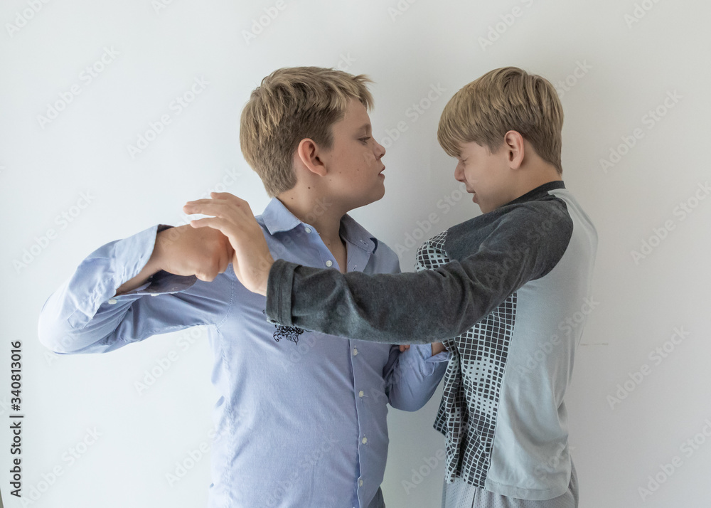 boys are fighting. bullying at school. the boy is attacking week boy ...