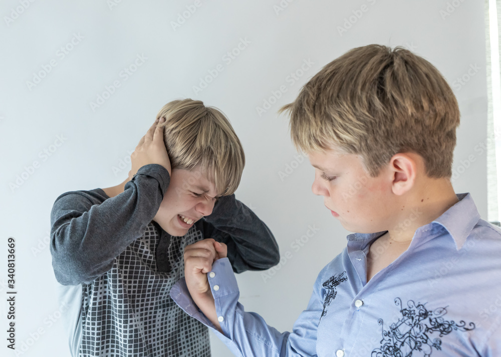 boys are fighting. bullying at school. the boy is attacking week boy ...