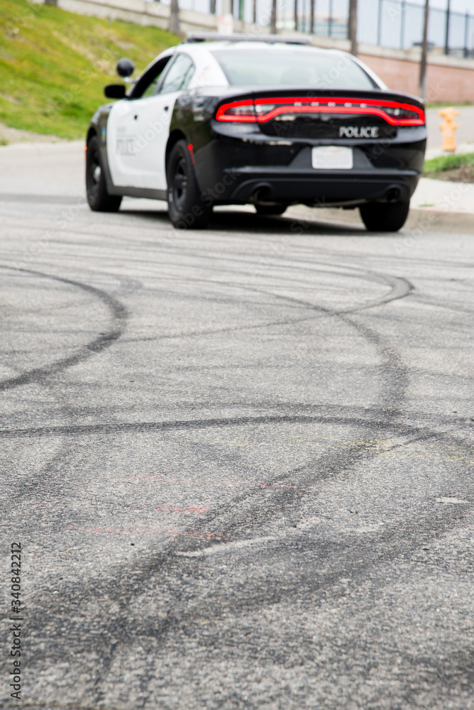 Tire marks in the road from cars doing donuts. with a blurred police ...