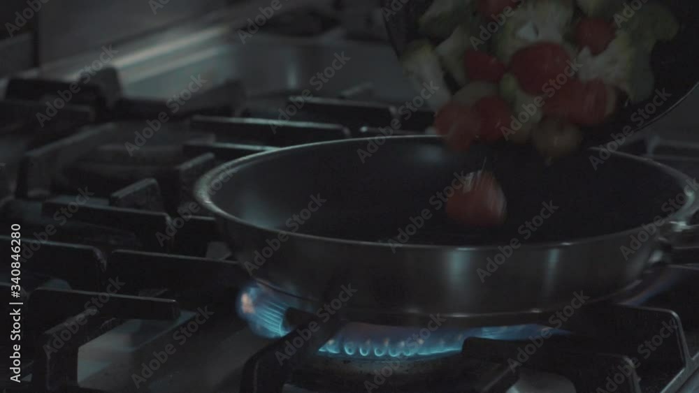 Vidéo Stock Adding vegetables into a frying pan with hot oil on the ...