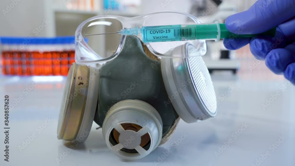 The gray hazard mask with the coronavirus or Covid-19 vaccine syringe ...