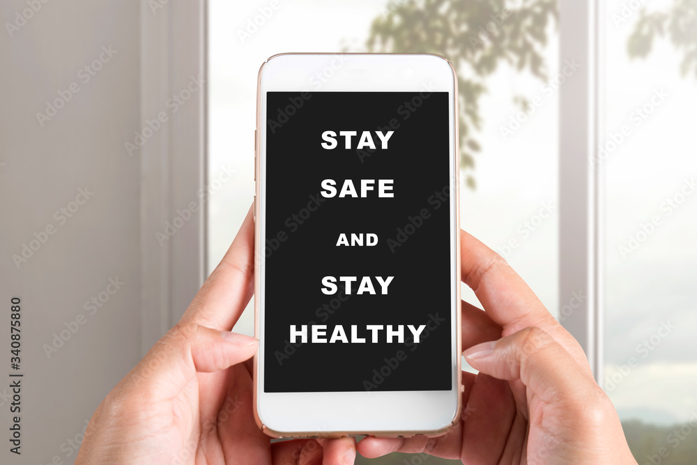 Hands holding a mobile phone with a message for Stay safe and stay ...