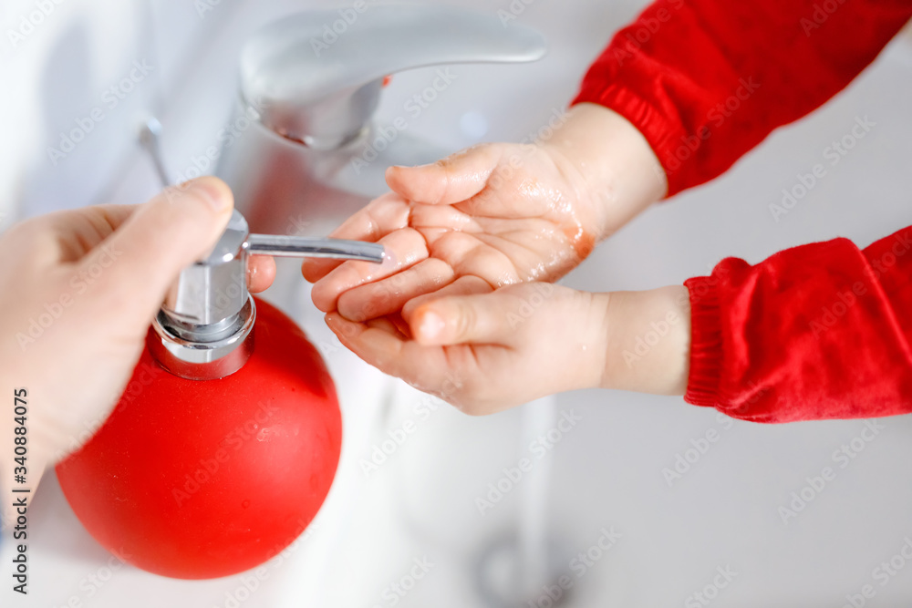 Closeup of little toddler girl washing hands with soap and water in ...