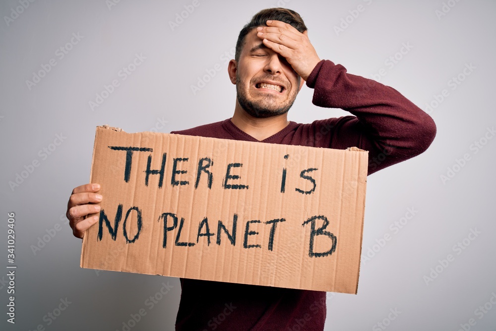 Young activist man holding protest banner for climate change and ...