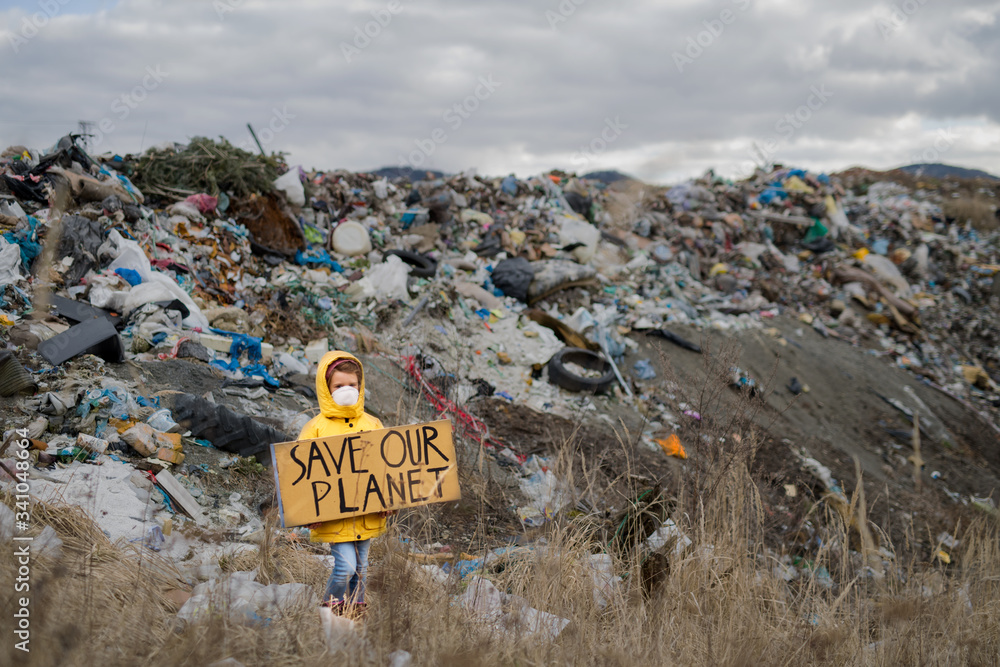 Small child holding placard poster on landfill, environmental pollution ...
