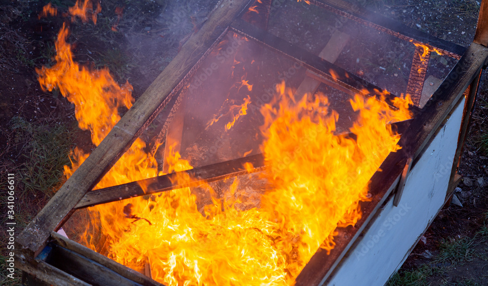 Fire coils over a burnt building. A pile of coals at the site of a ...