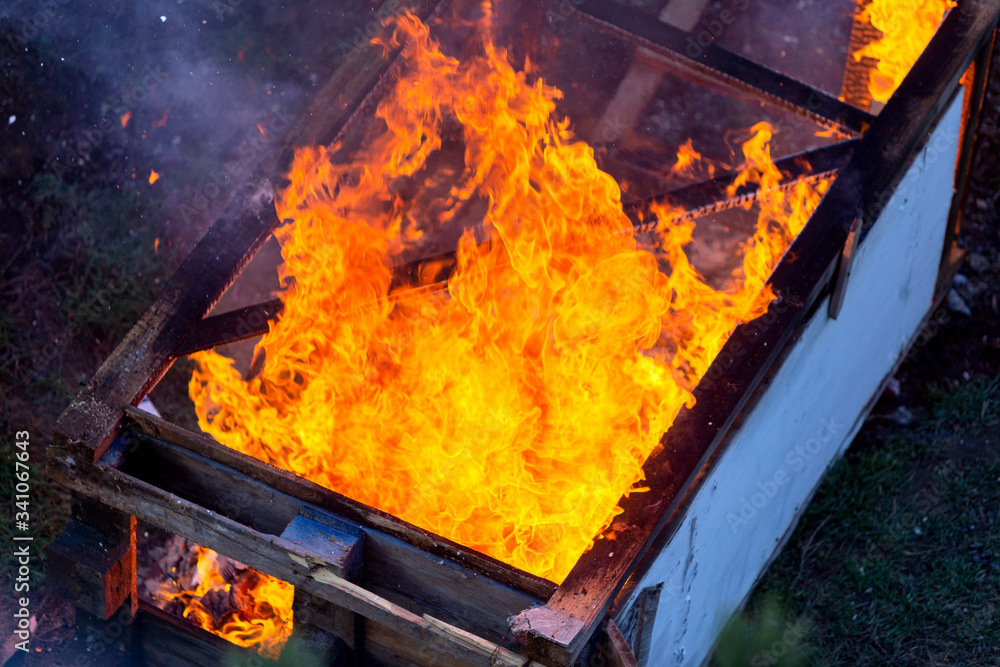 Fire coils over a burnt building. A pile of coals at the site of a ...