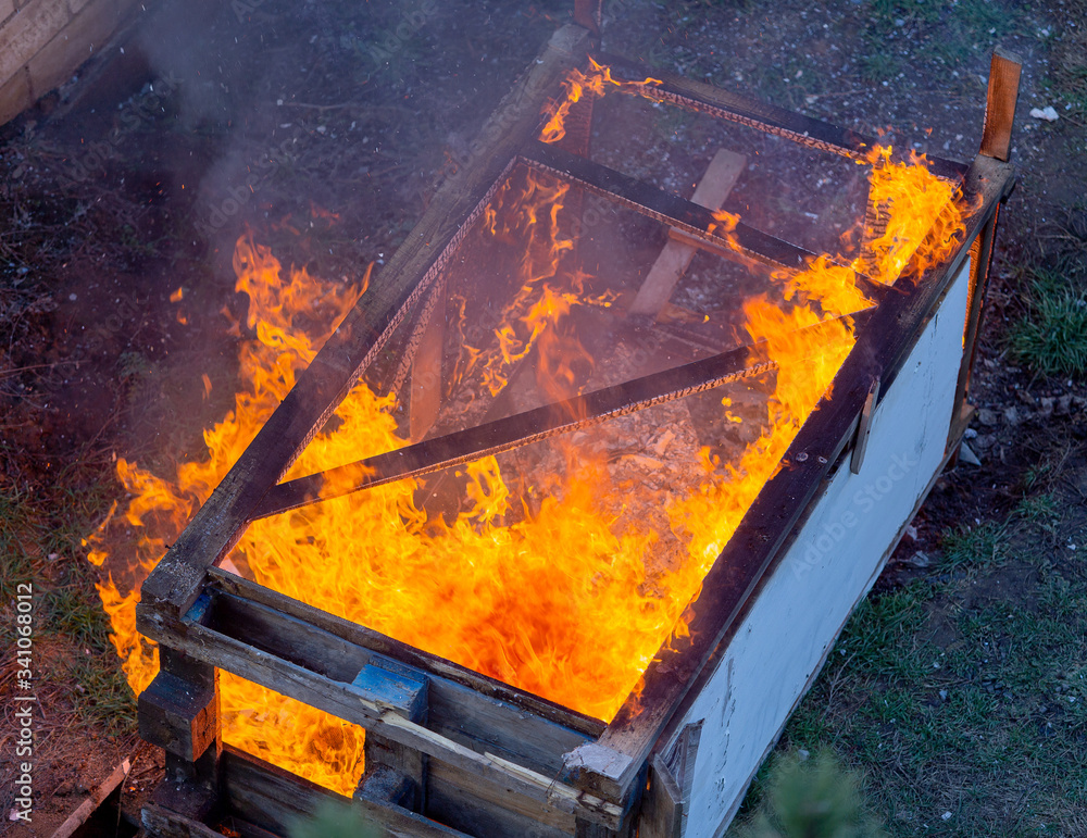 Fire coils over a burnt building. A pile of coals at the site of a ...