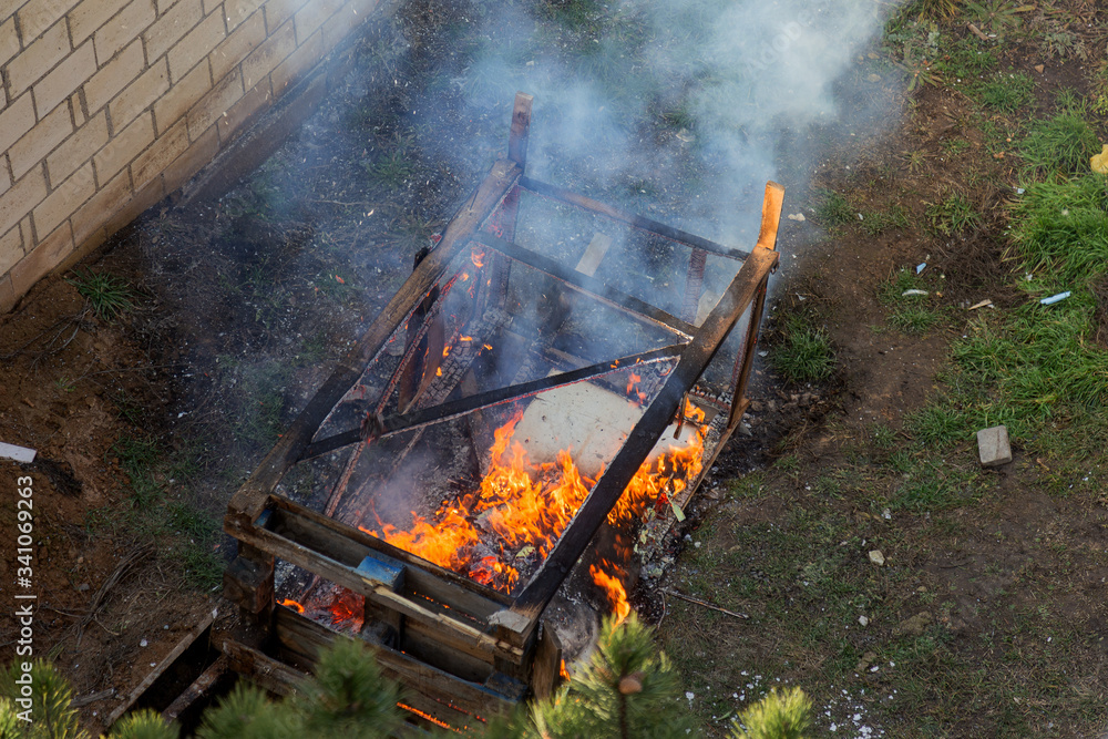 Fire coils over a burnt building. A pile of coals at the site of a ...