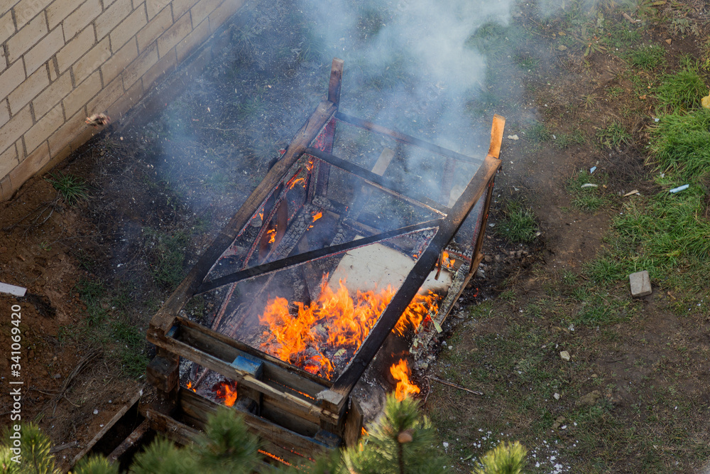 Fire coils over a burnt building. A pile of coals at the site of a ...