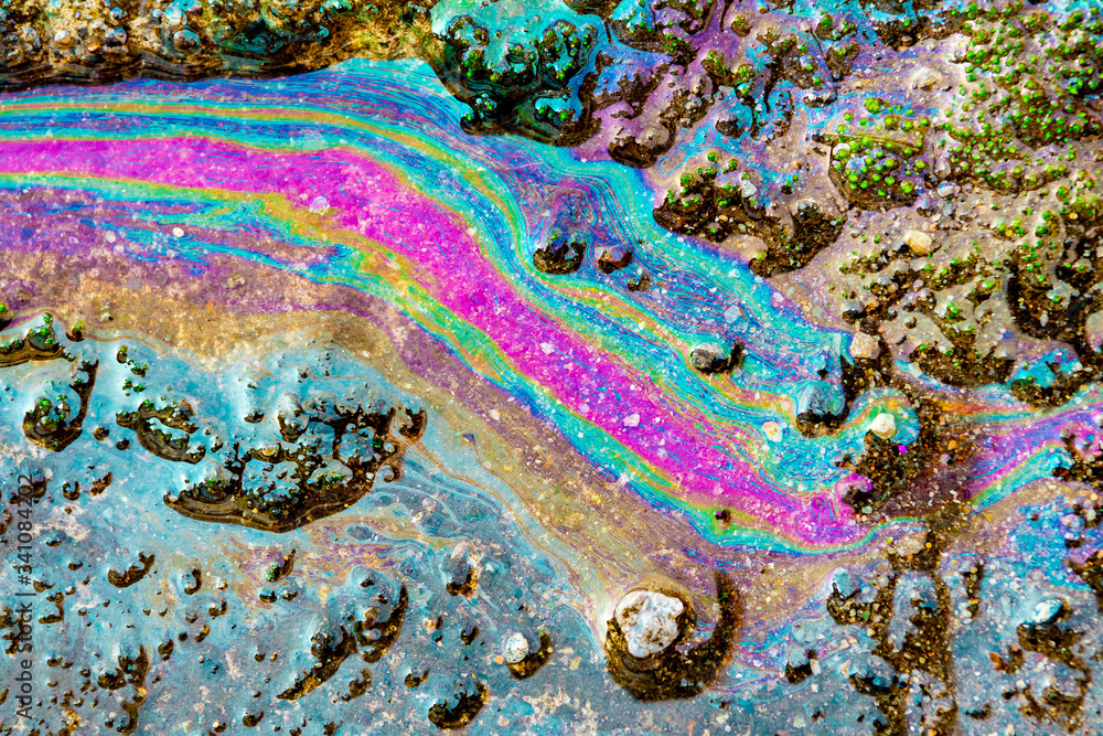 Petroleum spill on the ground. Bright colors. Pollution from cars and ...