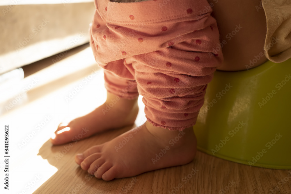 Peeing or pooping baby on a green pot. Weaning from a diaper. Pink ...