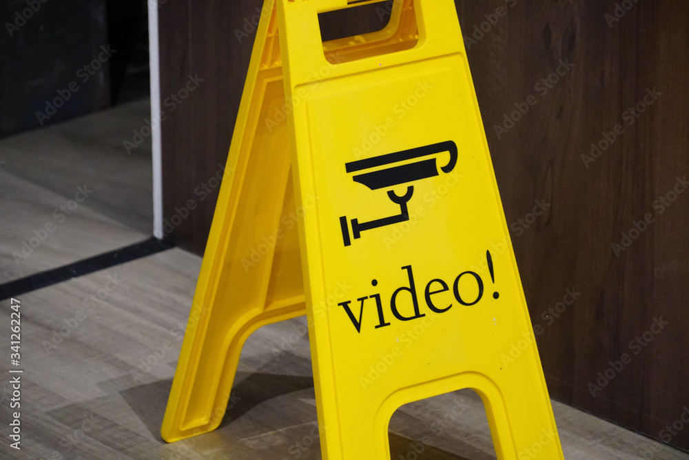 Yellow warning symbol of a surveillance camera in operation Stock Photo ...