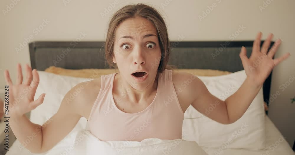 Good looking woman holding her head with both hands while oversleep and ...