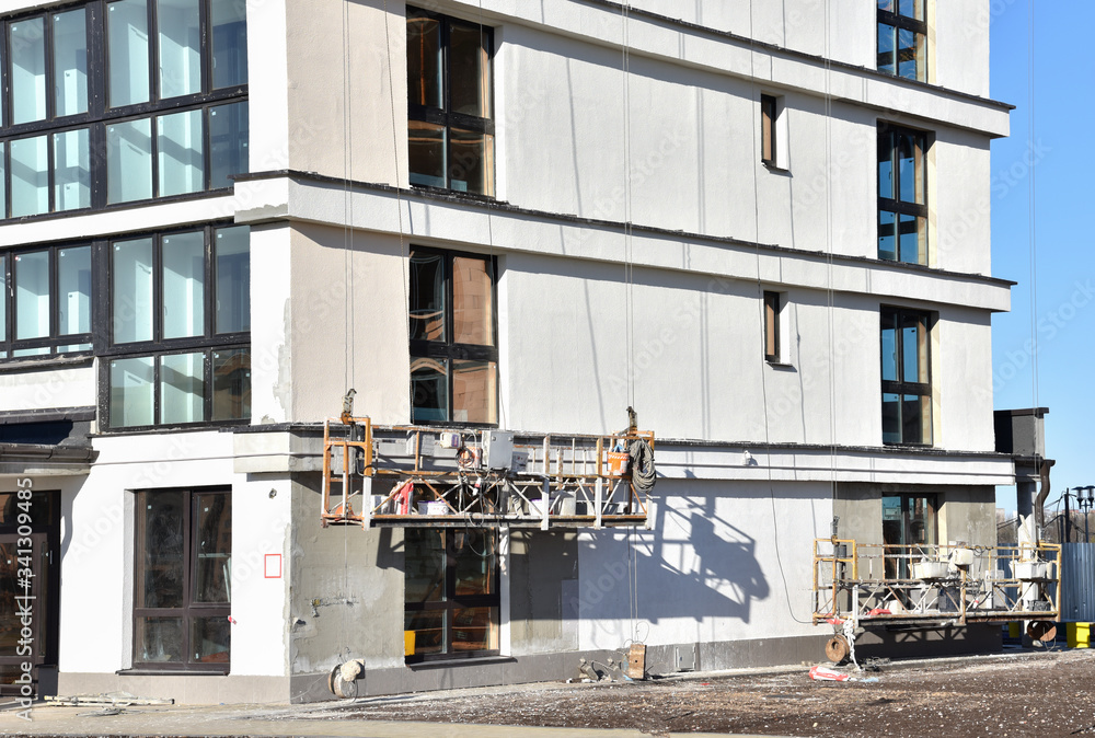 Suspended construction cradle on the background facade of the building ...