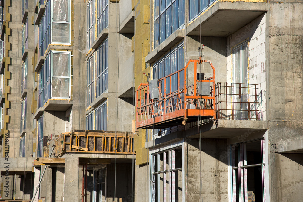 Suspended construction cradle on the background facade of the building ...