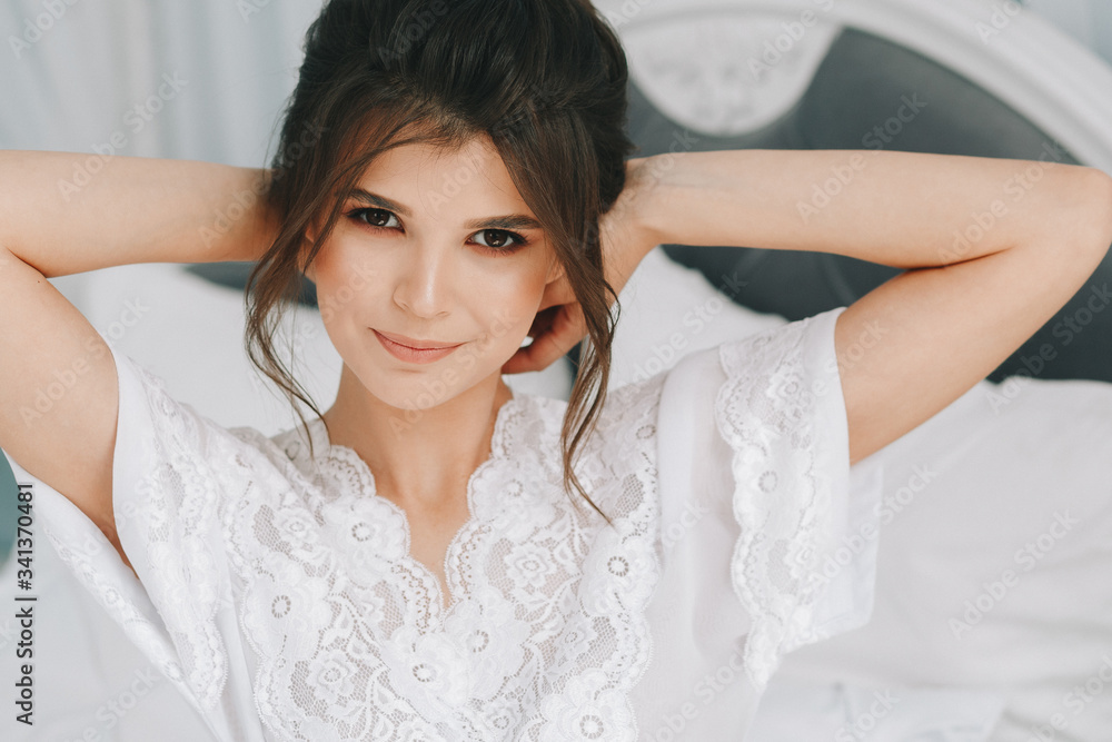 large boudoir portrait of a young girl in a bathrobe in a four-poster ...