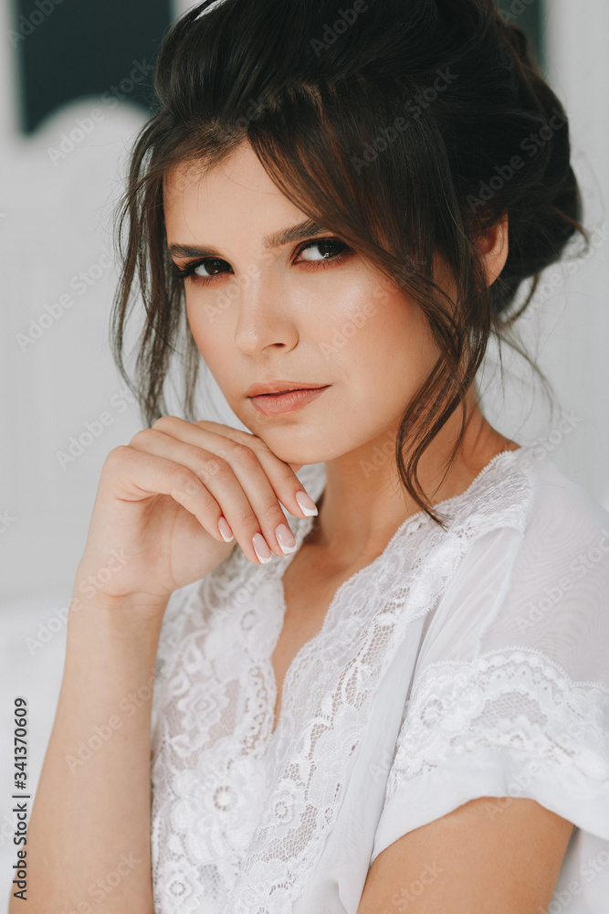large boudoir portrait of a young girl in a bathrobe in a four-poster ...