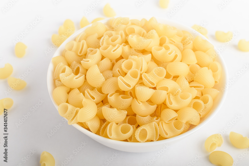 Many dried cornetti rigati traditional Italian pasta in a white bowl ...