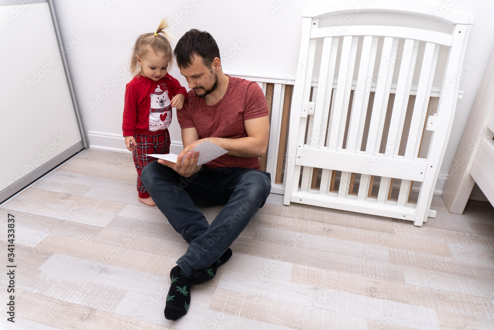 Cute baby help father to assemble cot, dad shows his child manual ...