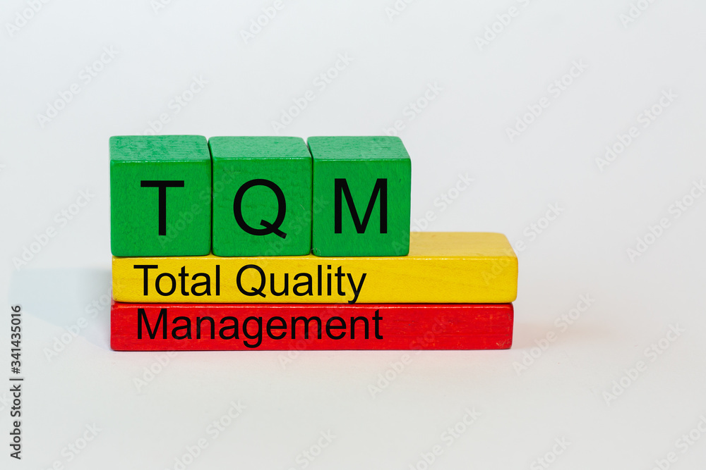 the letters TQM stand as an abbreviation on colorful blocks that show ...