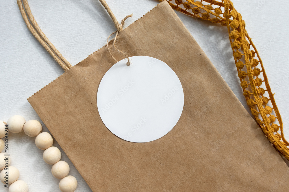 Round gift tag label on a brown paper bag - flat lay gift tag mockup ...