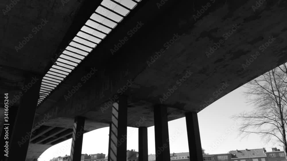 Slowly surveying the underside of an expansive urban concrete and steel ...