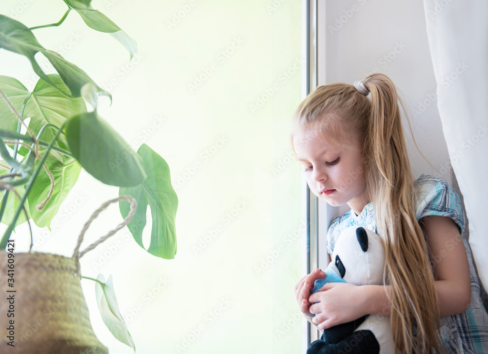 Sad child girl by the window Stock Photo | Adobe Stock