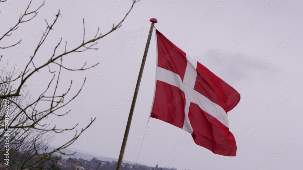 Danish Flag flaps in wind in slow motion, cloudy day in rural Denmark ...
