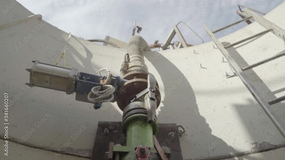 Metal water pipe inside a concrete tube tank with big industrial pump ...