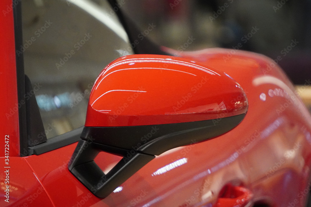 Rearview mirror of a red sport car, glare from the sun in the glass of ...