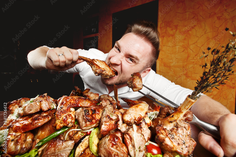 Foto de Crazy hungry man eating mix grill meat. Emotional content for ...