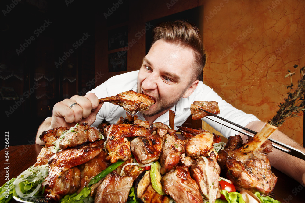 Crazy hungry man eating mix grill meat. Emotional content for ...