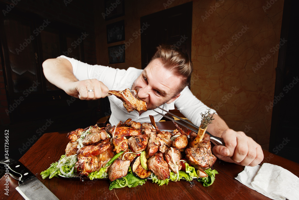 Crazy hungry man eating mix grill meat. Emotional content for ...