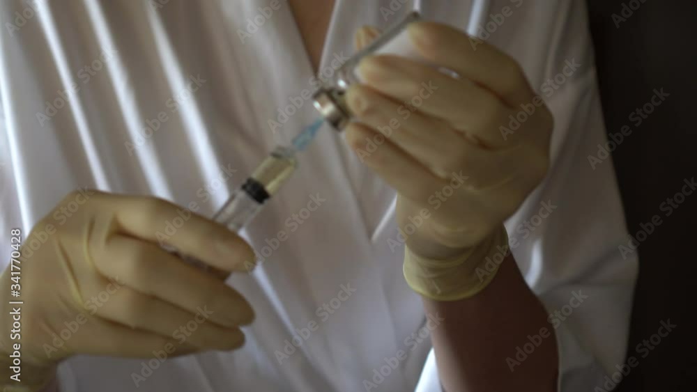 Self-injection of antibiotics. Female preparing needle for injecting ...