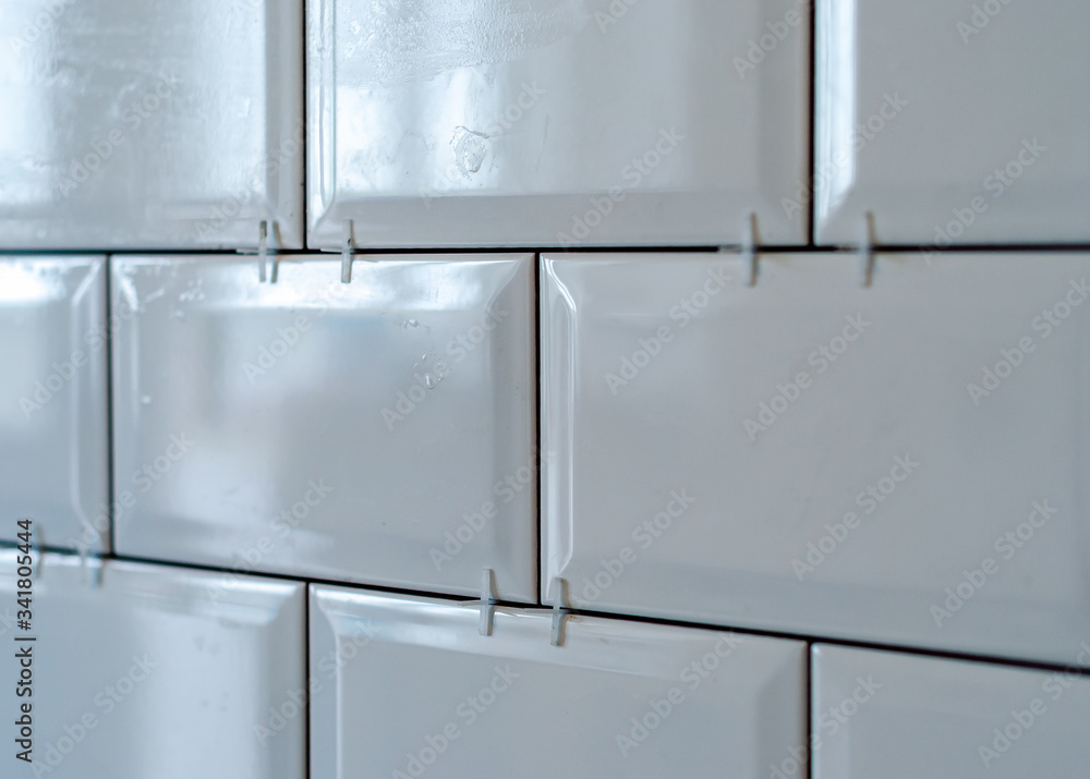 Ceramic tile laying. Placing white tile spacers. Installed new white ...