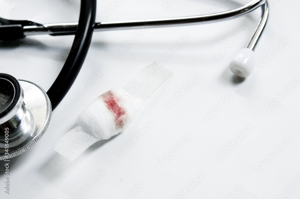 Blood on cotton wool and white plaster on white background with ...